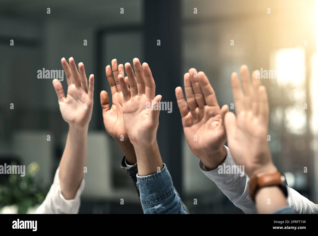 Taking it to the top. a group of unrecognizable businesspeople raising ...