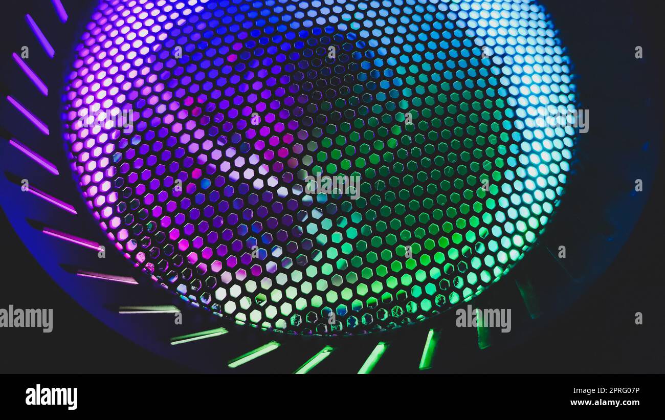 Colorful led lights of computer fan shines through the protective grid ...