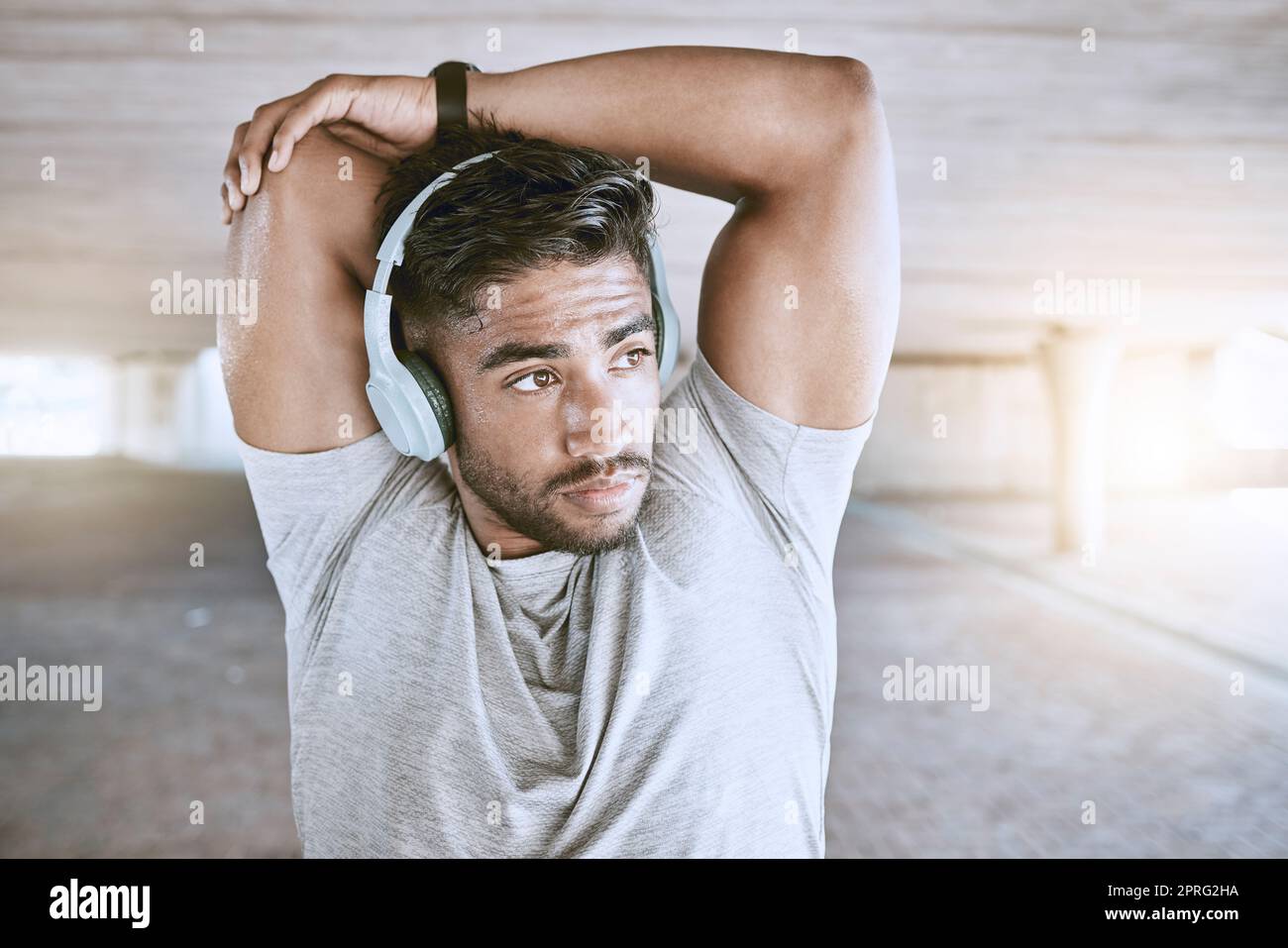 Fitness man training with headphones stretching, listening to music or ...