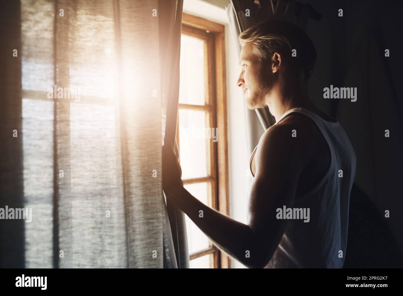 The weather looks perfect today. a handsome young man looking out of a ...