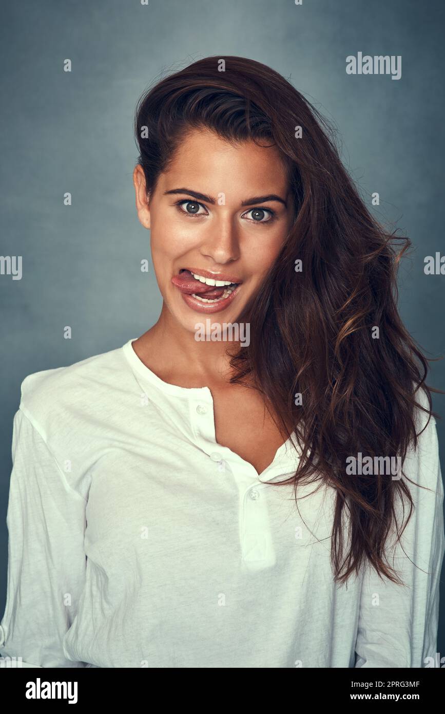 Let your hair down. Portrait of a beautiful young woman pulling a funny ...