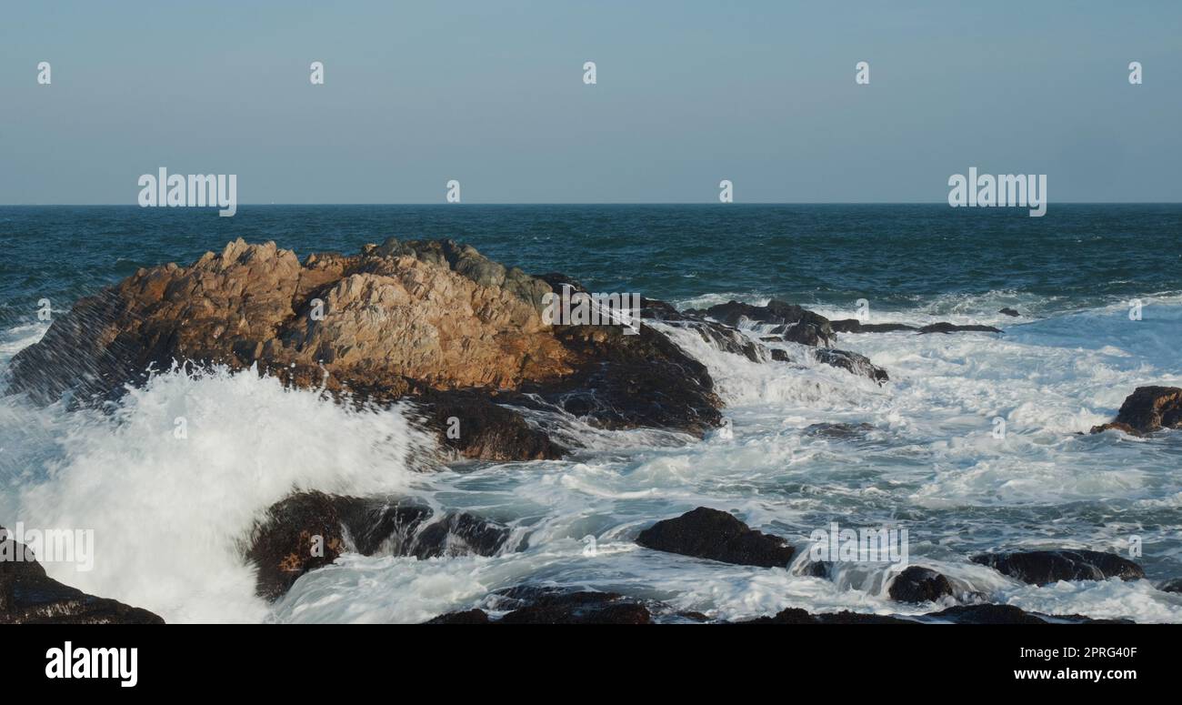 Ocean waves splash against rock on island Stock Photo - Alamy