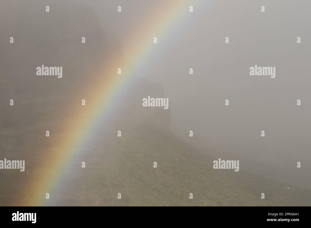 Rainbow and Tirajana cliffs in the fog Stock Photo - Alamy
