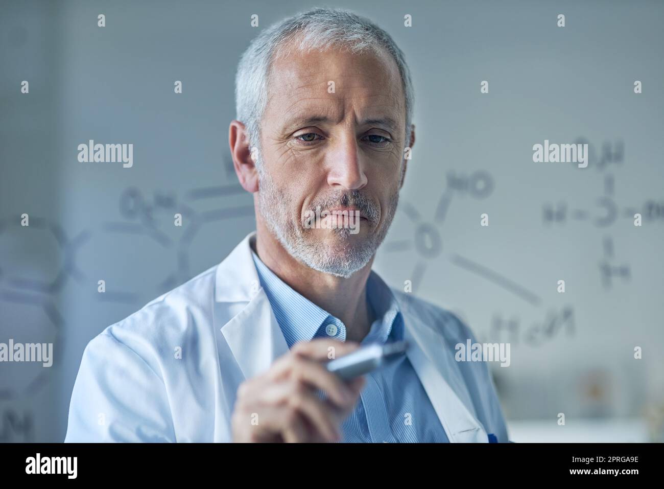 Seeking scientific answers. a male scientist drawing molecular ...