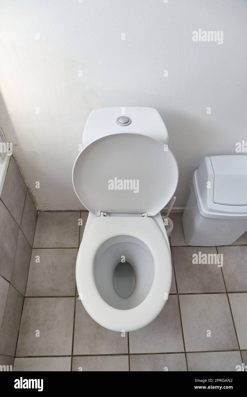 Toilet in a narrow white bathroom Stock Photo - Alamy