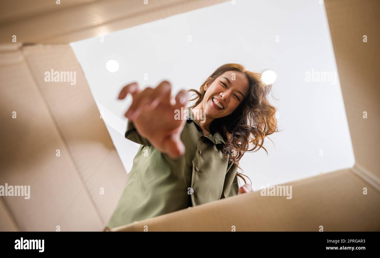 Happy Asian young woman opening carton box from internet store order ...