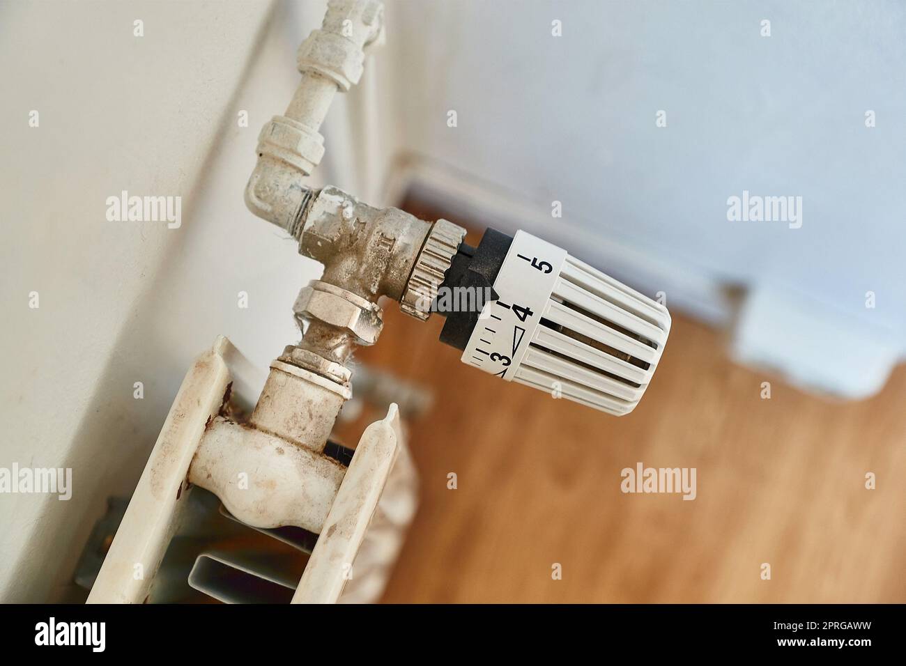 Heating radiator detail in a room, adjusting valve Stock Photo - Alamy