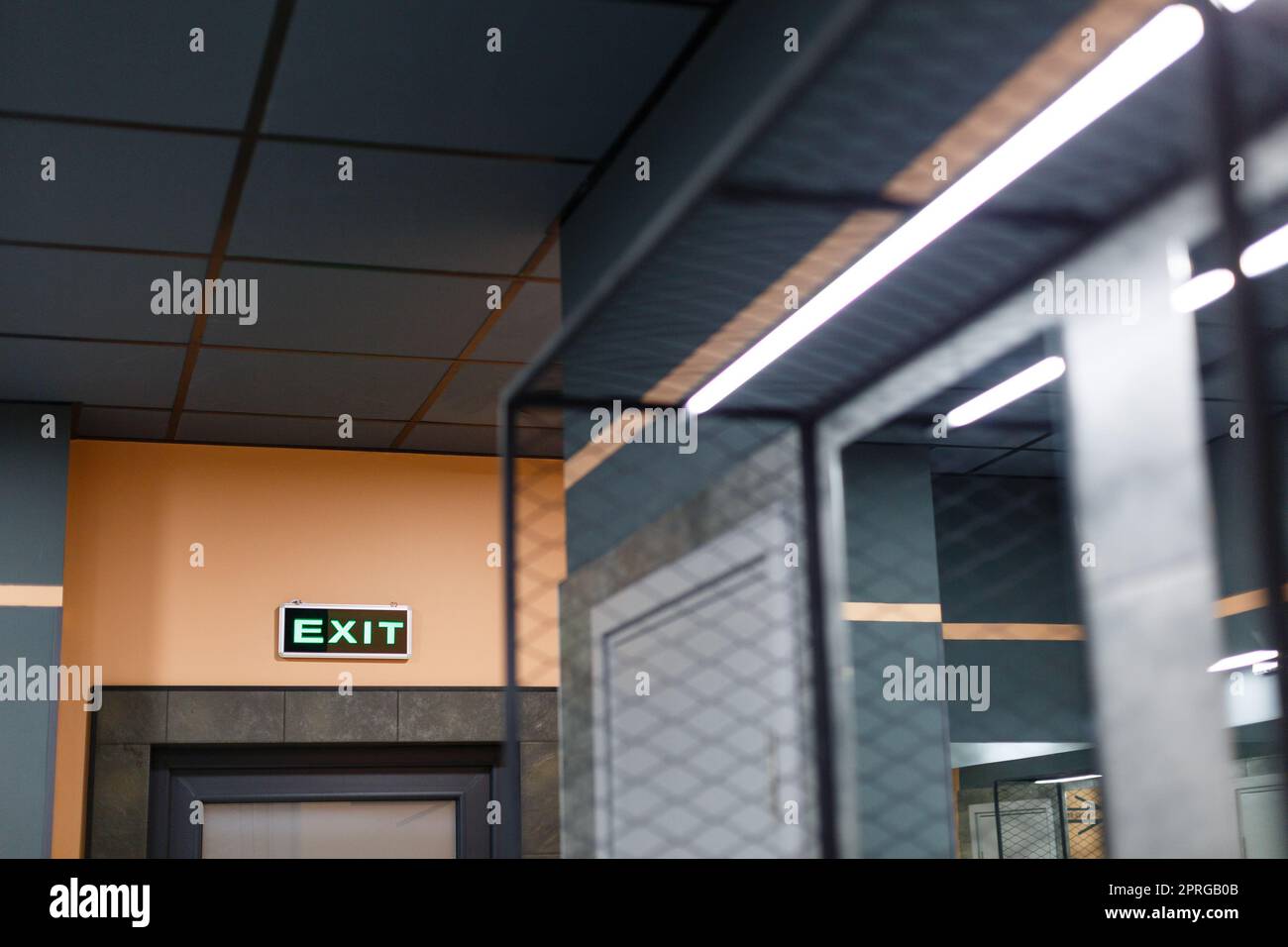 Exit sign in Ukrainian and English hangs above door in public place ...