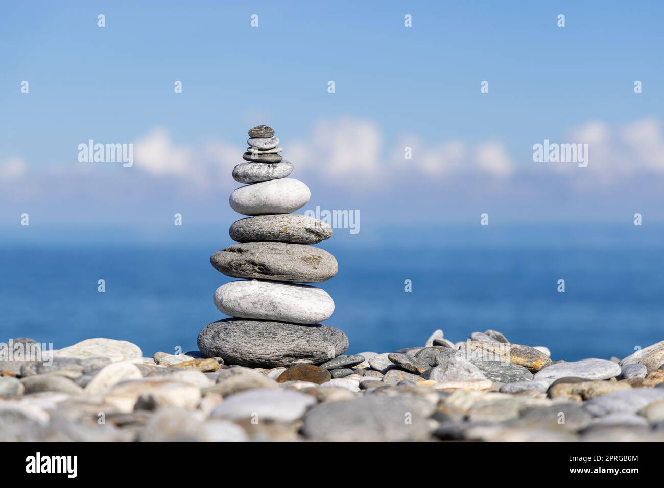 Rock balancing on ocean beach Stock Photo - Alamy