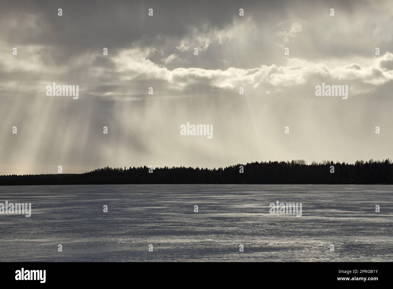 Lakeside landscape raining on the horizon over frozen lake in Finland ...