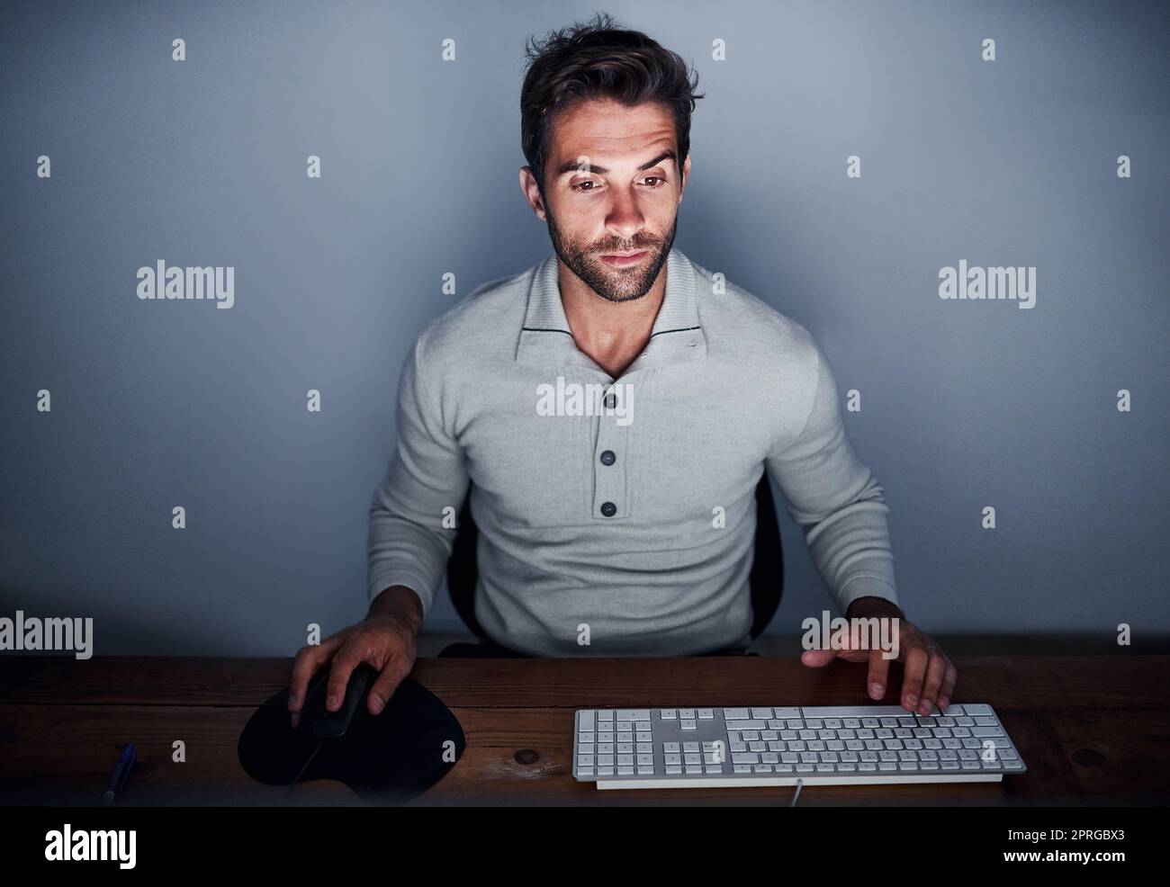 All the info right at his fingertips. a handsome young man working late ...