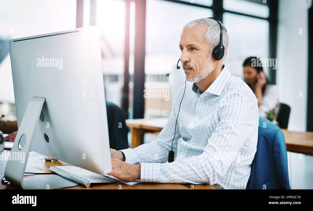 Helping people is what he does. a handsome mature male operator working ...