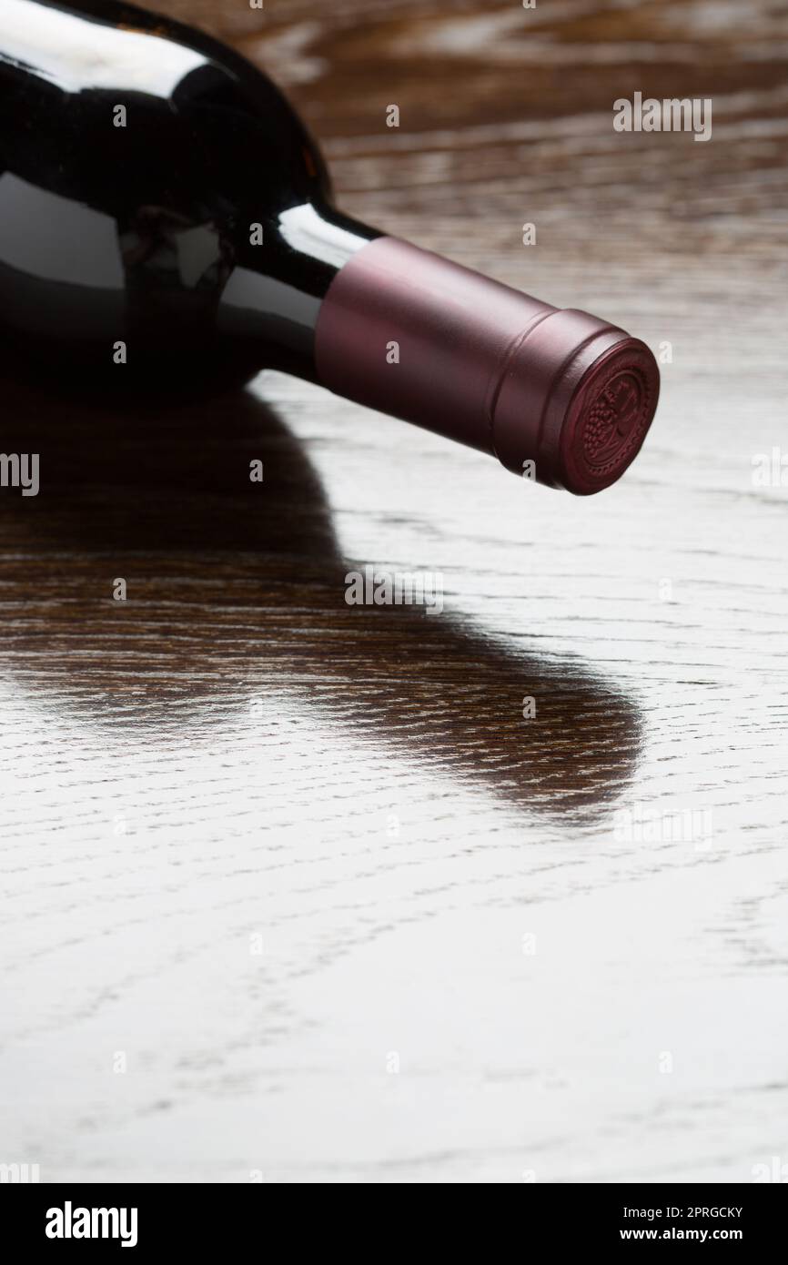 Red Wine Bottle Laying on a Wood Surface Fading Down to White Stock ...