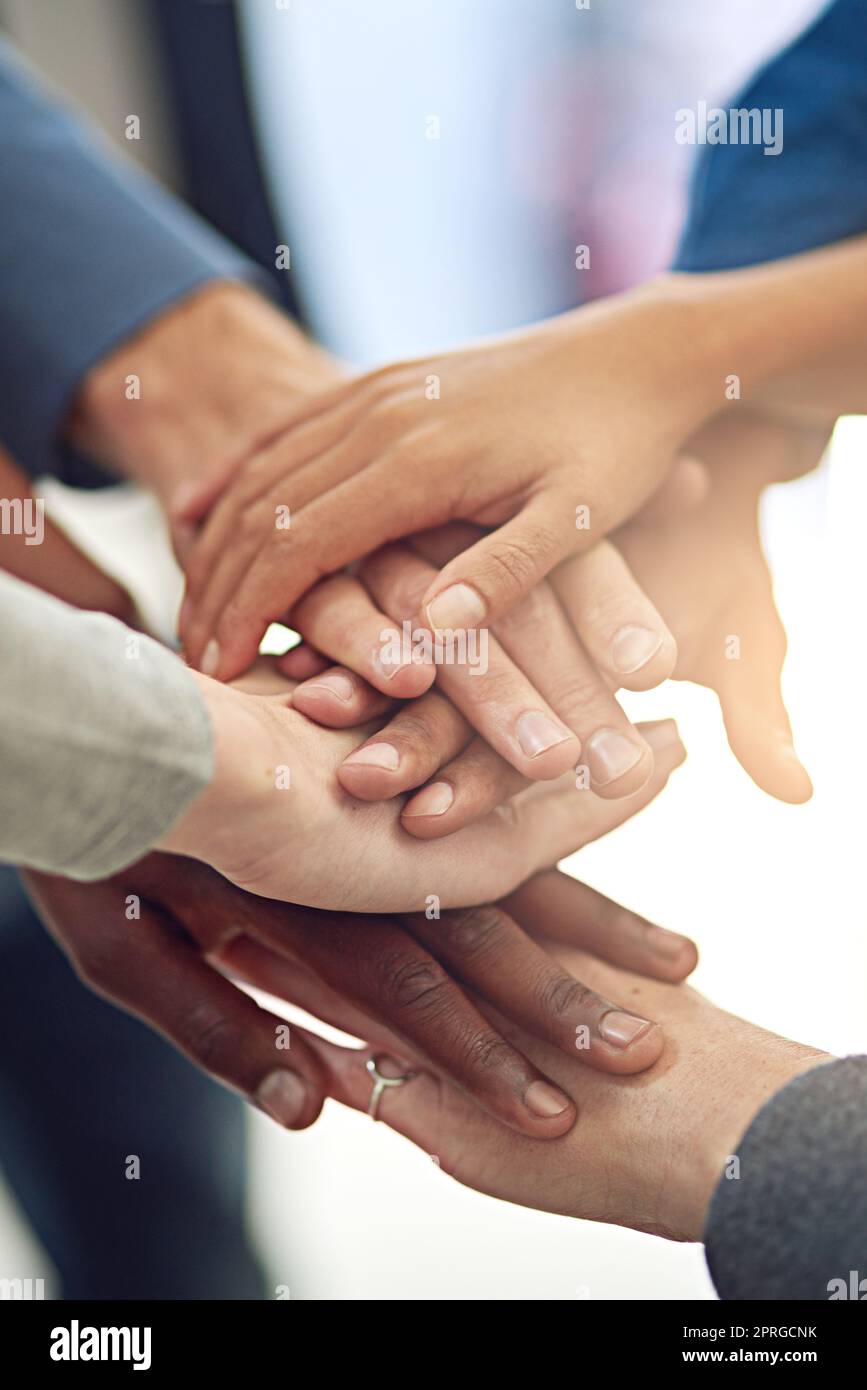 Strength in unity. a group of colleagues joining their hands in unity ...