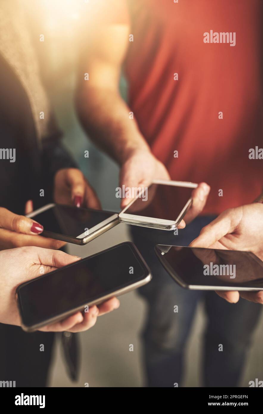 Using their cellphones for research. a group of colleagues using their ...