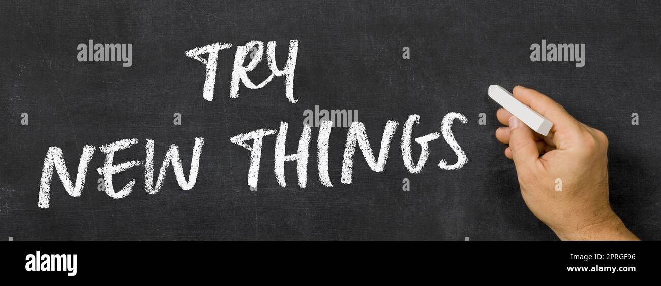 Text written on a blackboard - Try new things Stock Photo - Alamy
