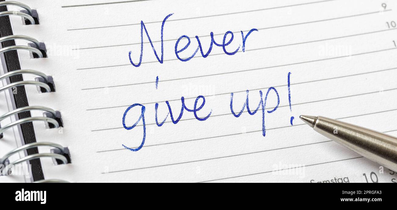 Never give up written on a calendar page Stock Photo - Alamy