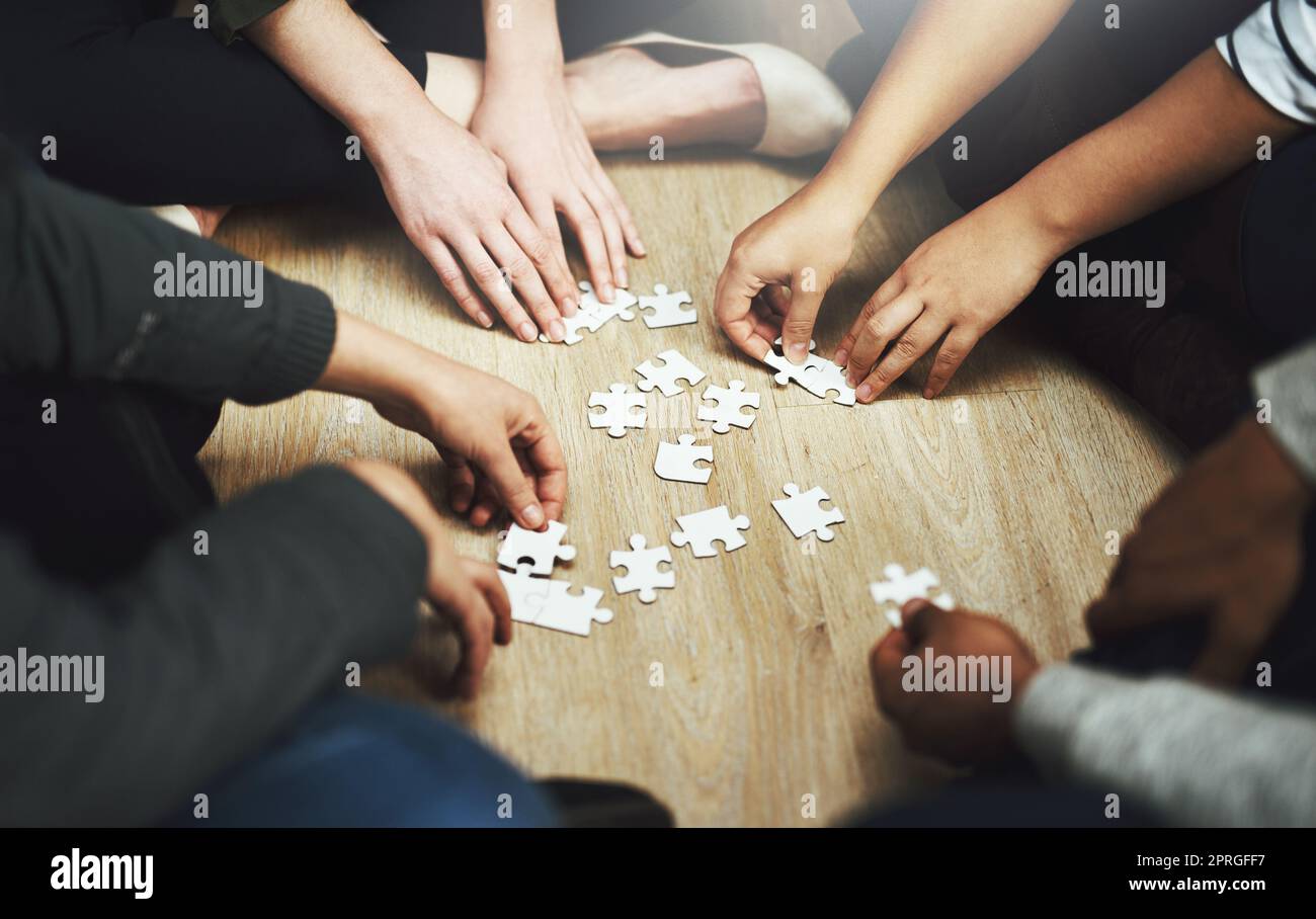 Every piece has its place. a group of unrecognizable people fitting ...