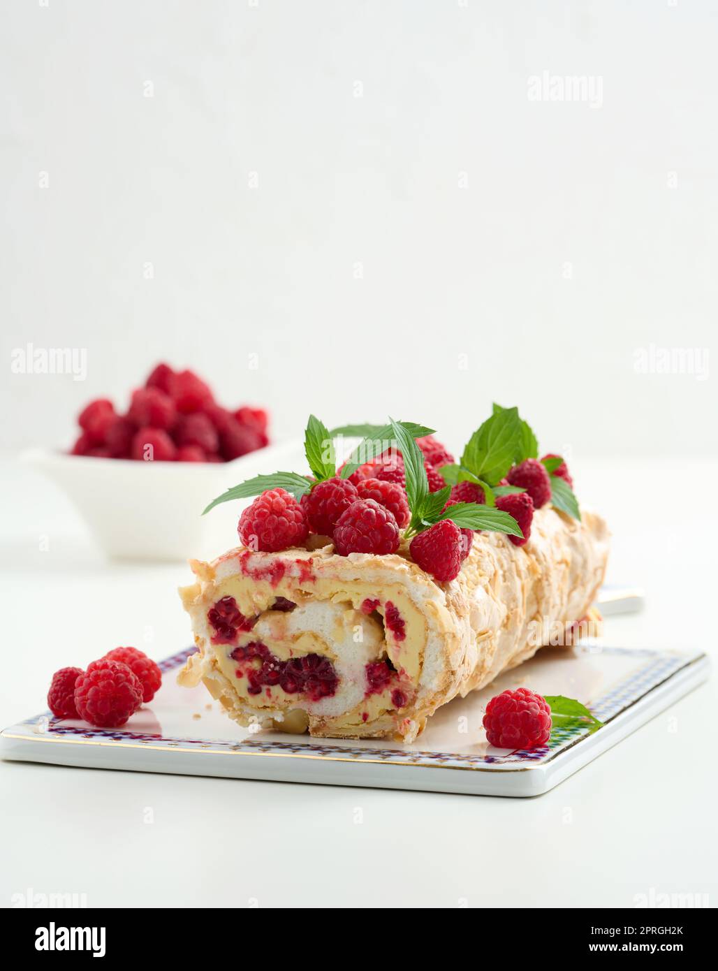 Baked meringue roll with cream and fresh red raspberry, white ...