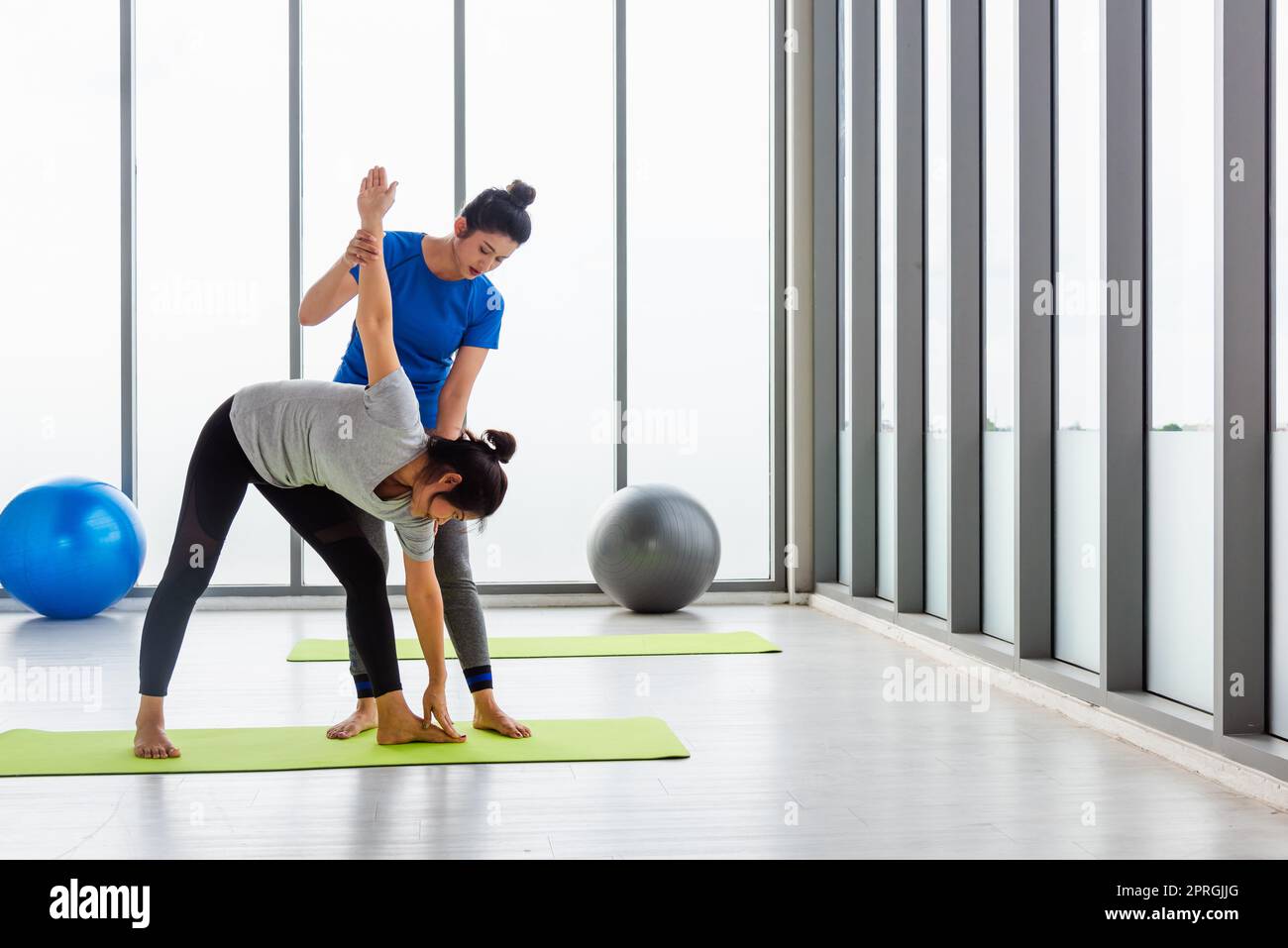 woman teacher teach adult student doing yoga stretching position in ...