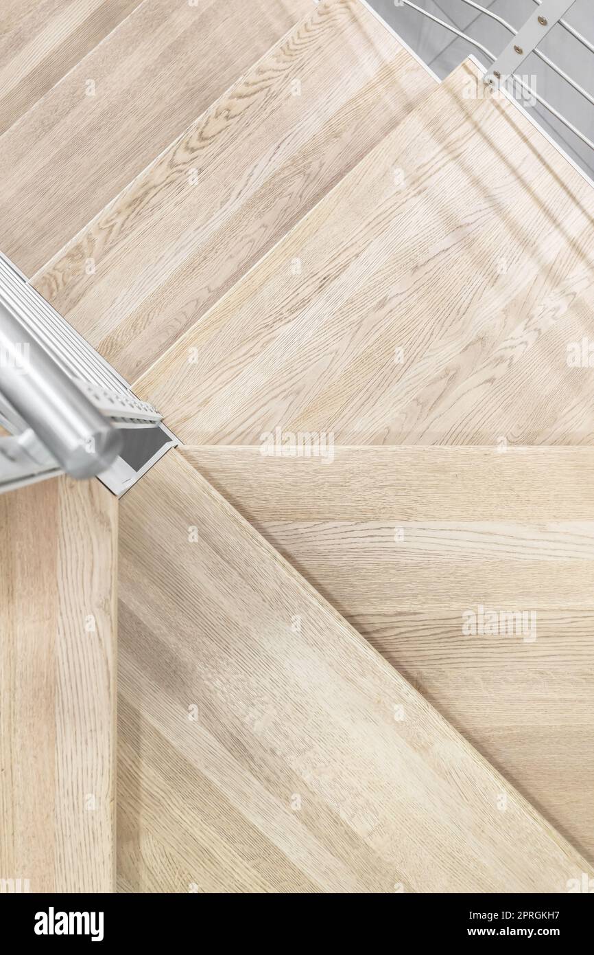 Close-up detail view of natural wooden stair steps. Metal handrail ...