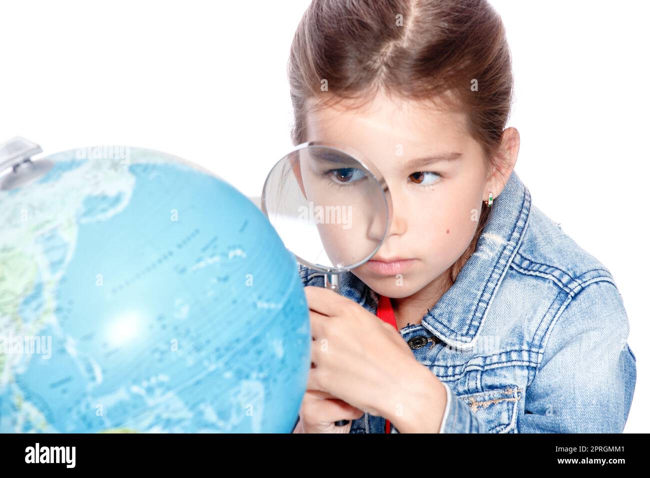 Curious little girl looking through magnifying glass on globe Stock ...