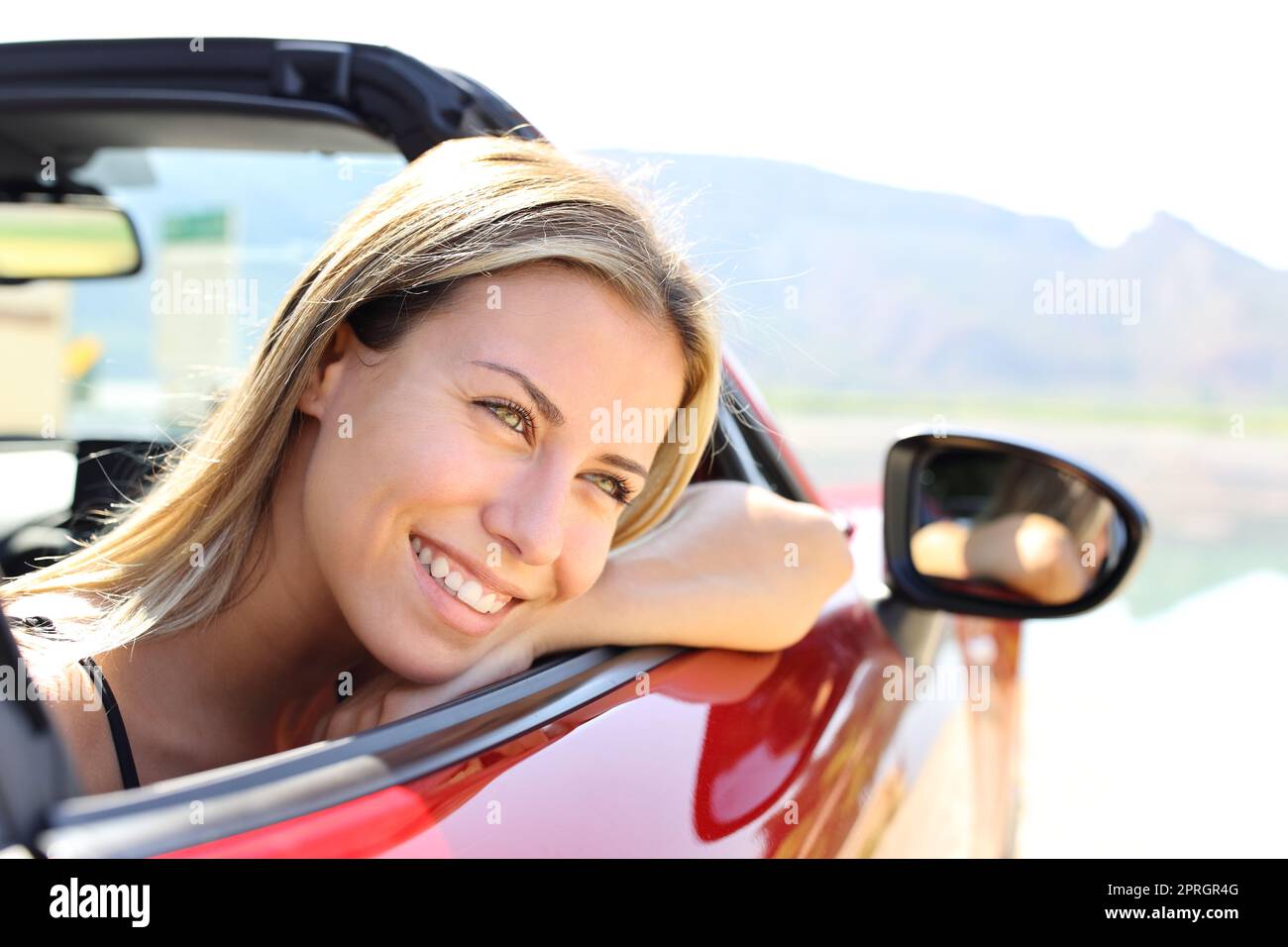 Happy convertible car driver smiling and resting looking away Stock ...