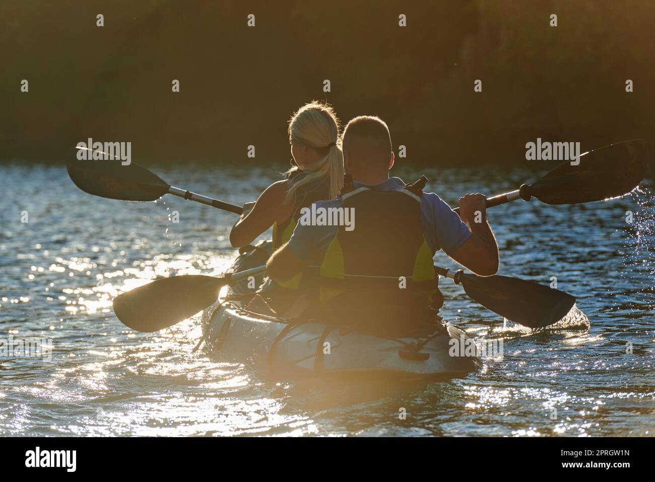 A young couple enjoying an idyllic kayak ride in the middle of a ...