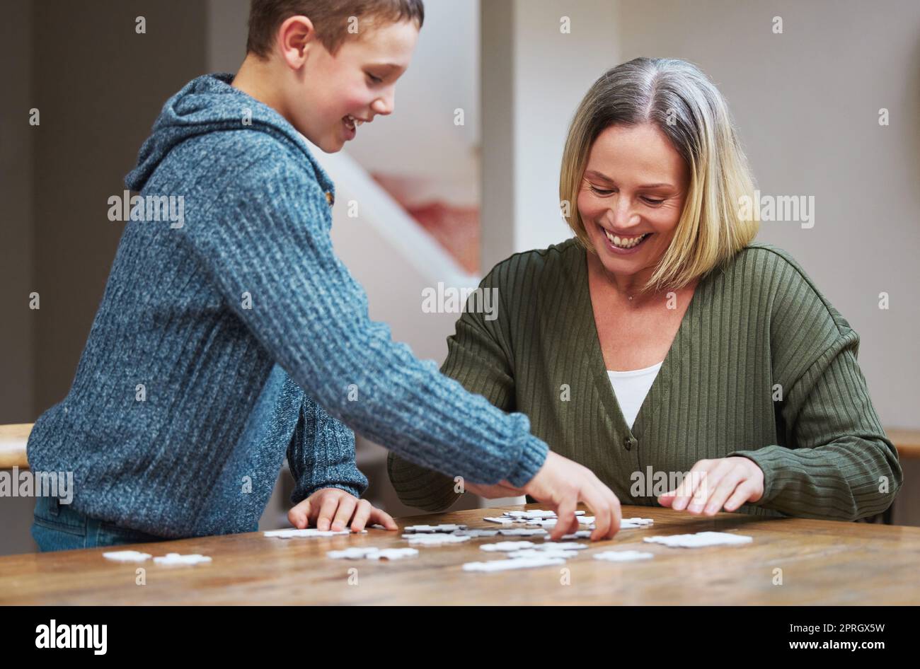 Puzzles are great for problem solving. a mother completing a puzzle ...