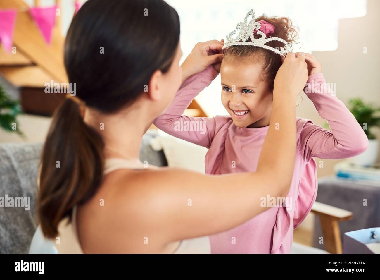 A princess needs her crown. a mother putting a crown on her daughters ...