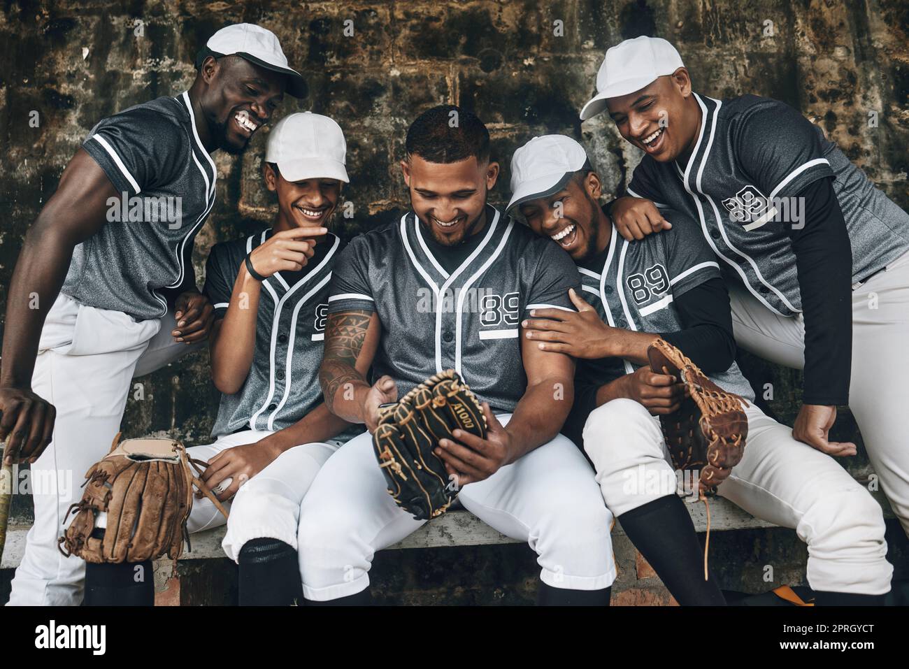 Baseball, sport and phone with a team of men on a bench after training ...