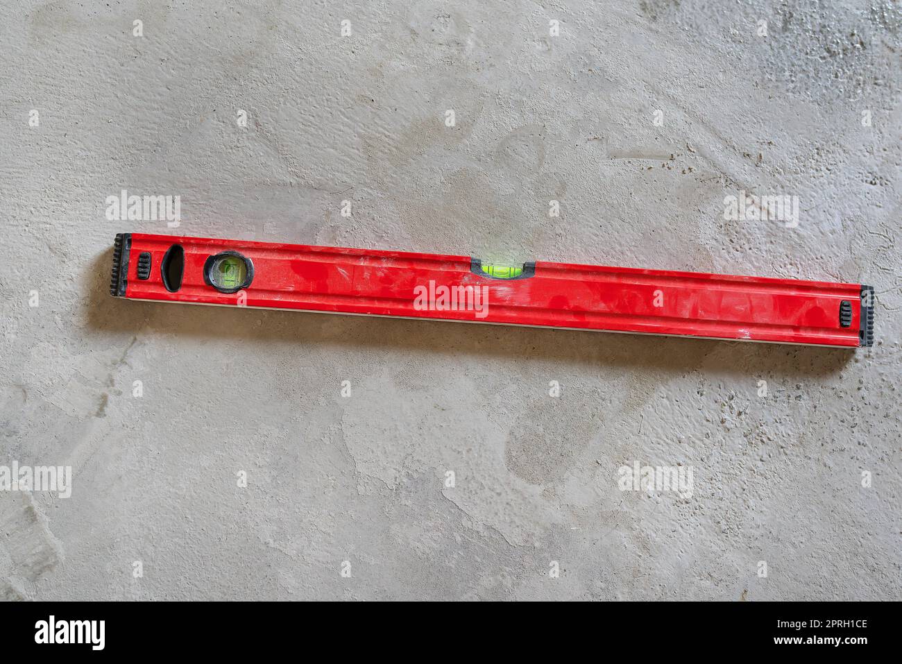 The construction technician is working by leveling the concrete floor ...