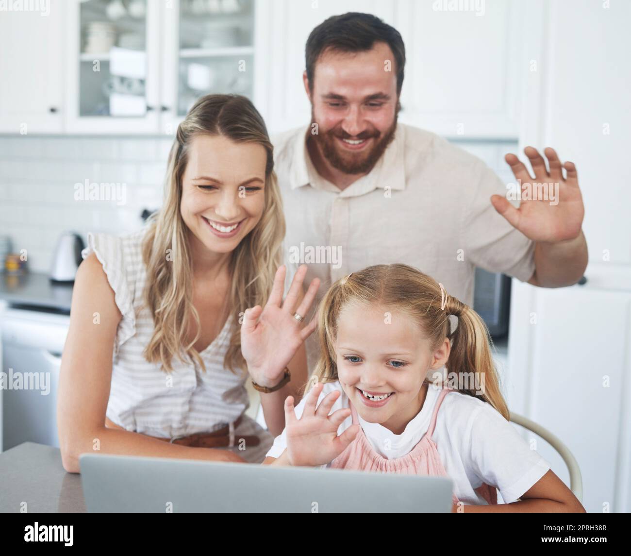 Happy family, wave and video call on laptop in kitchen with friends ...
