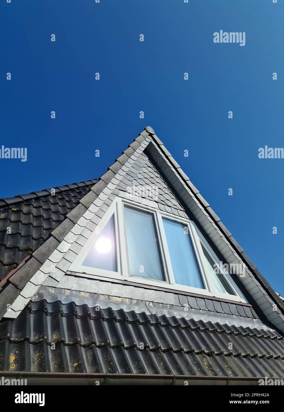 Open roof window in velux style with black roof tiles Stock Photo - Alamy