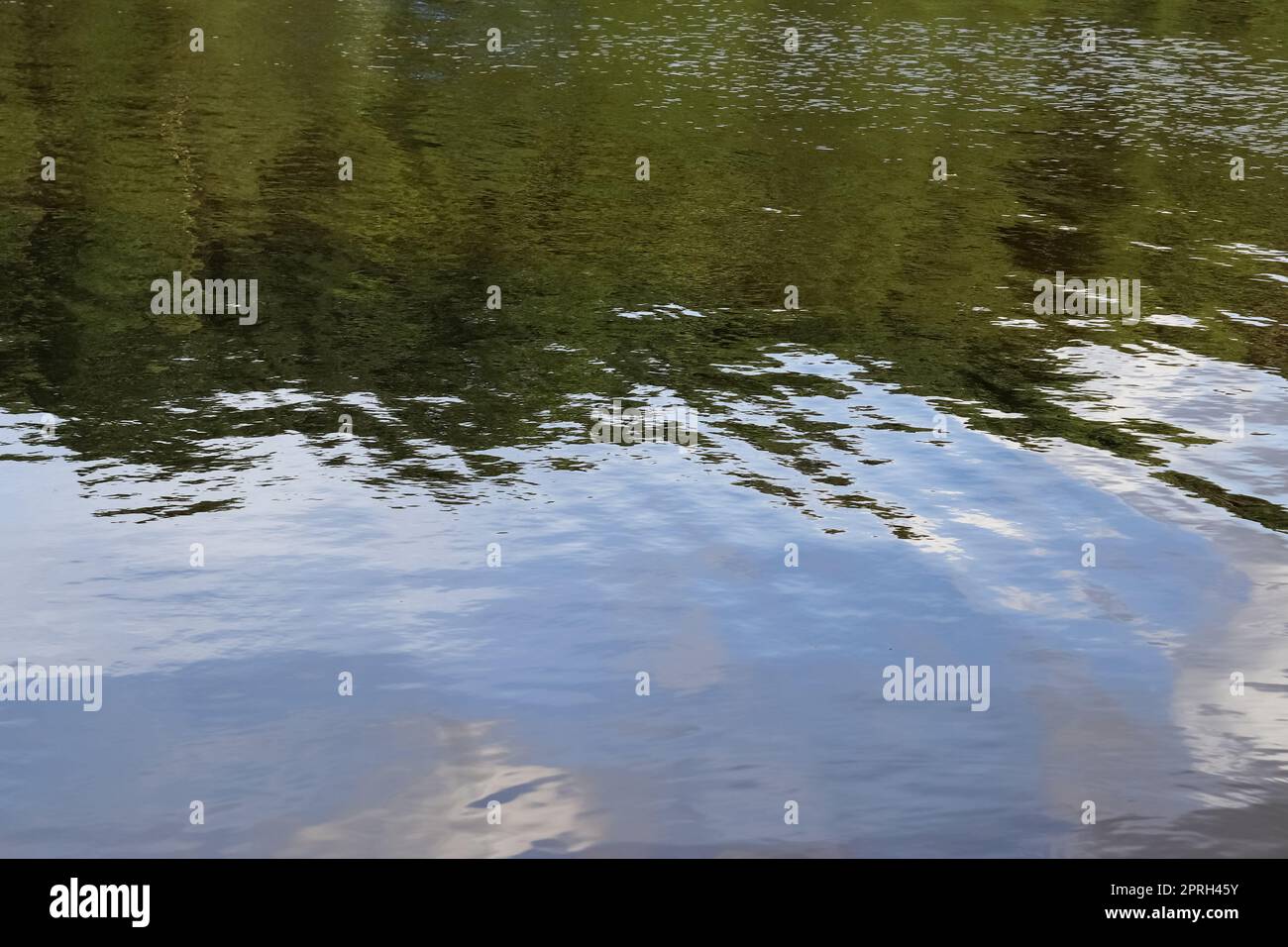 Water surfaces with waves and ripples and the sunlight reflecting at ...