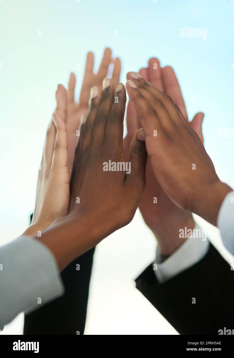 Team number one. a group of businesspeople giving each other a high ...