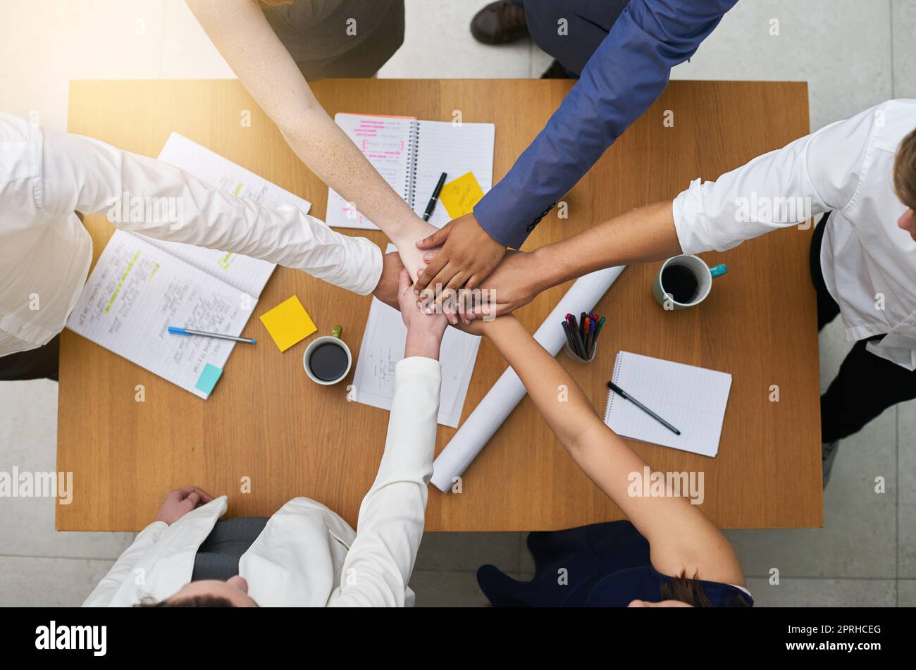 Working together as one. a group colleagues reaching their hands ...