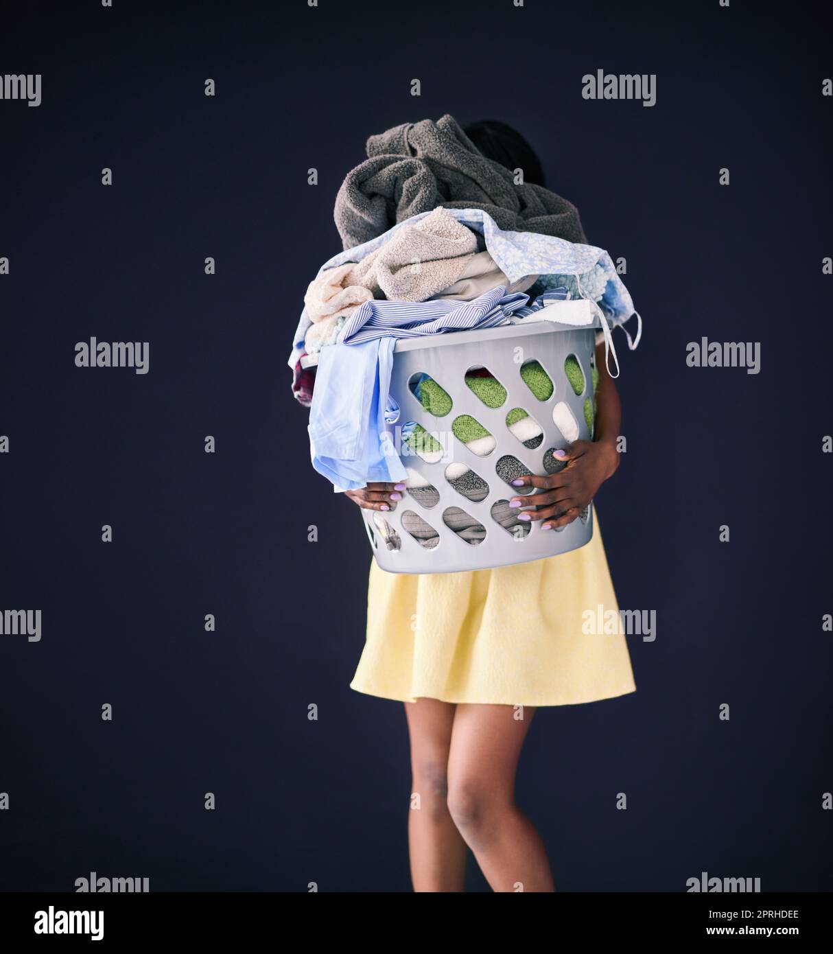 One big pile of laundry. a young woman carrying a basket full of ...