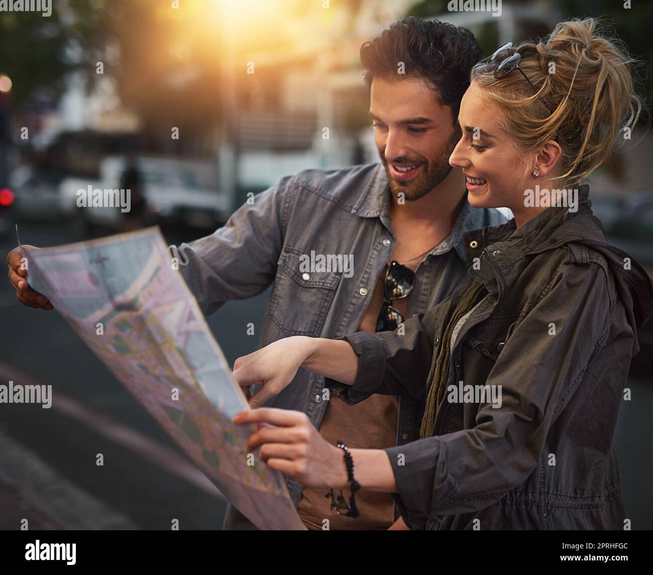 This should be our next stop. a young couple using a map while ...