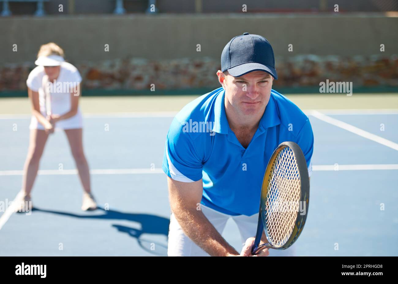 In position. A mixed doubles team standing ready to receive a serve ...