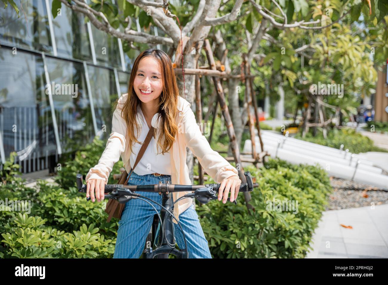 Happy Asian beautiful young woman riding bicycle on street outdoor near ...