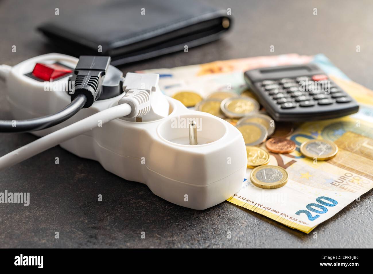 Electric plug, euro money and calculator on black table. Concept of ...