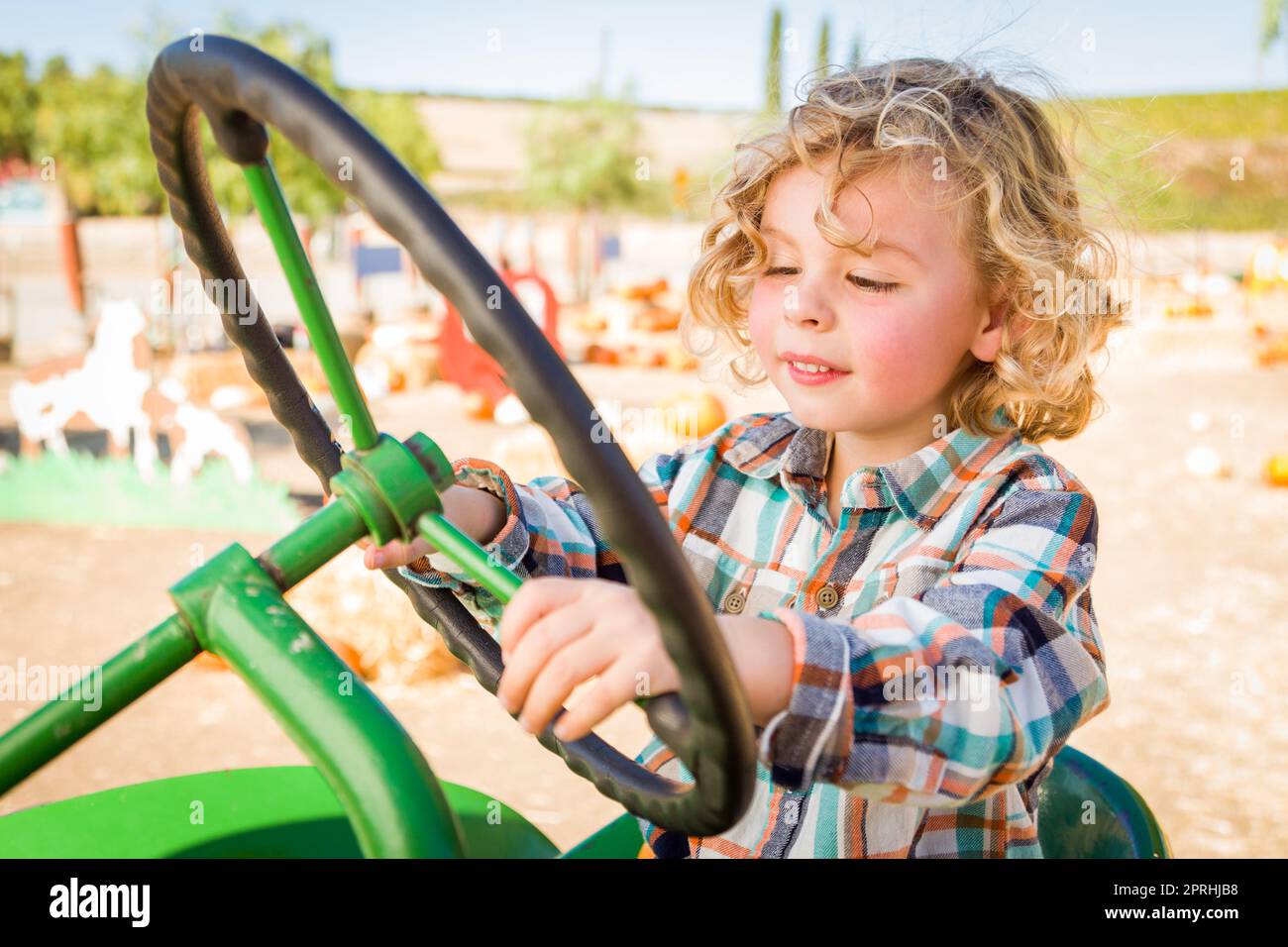 Little Boy Having Fun In A Tractor in a Rustic Ranch Setting at the ...