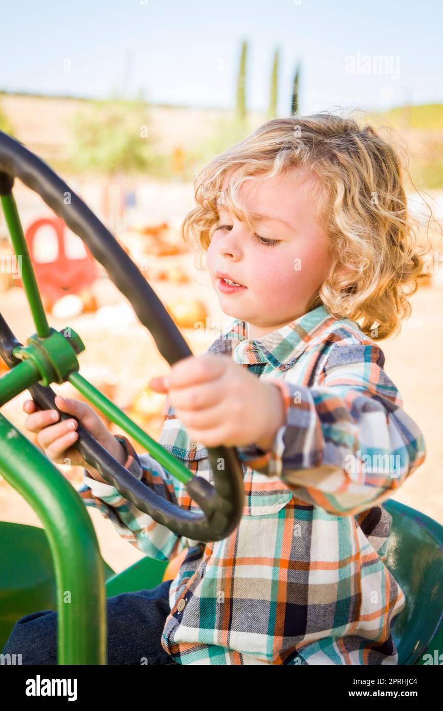 Little Boy Having Fun In A Tractor in a Rustic Ranch Setting at the ...