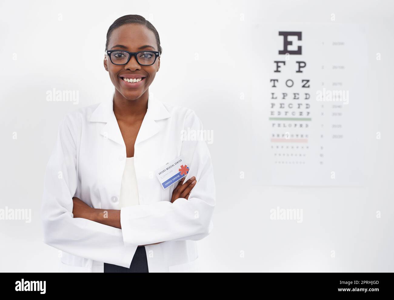Lets test those eyes. Portrait of a female optometrist standing beside ...