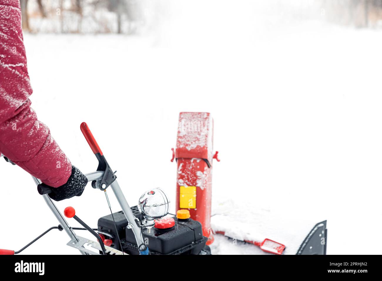 Man using red snowblower machine outdoor. Removing snow near house from yard Stock Photo - Alamy