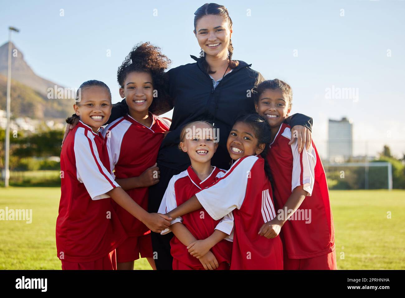 Football, happy and girl team with coach on a sport soccer field after ...