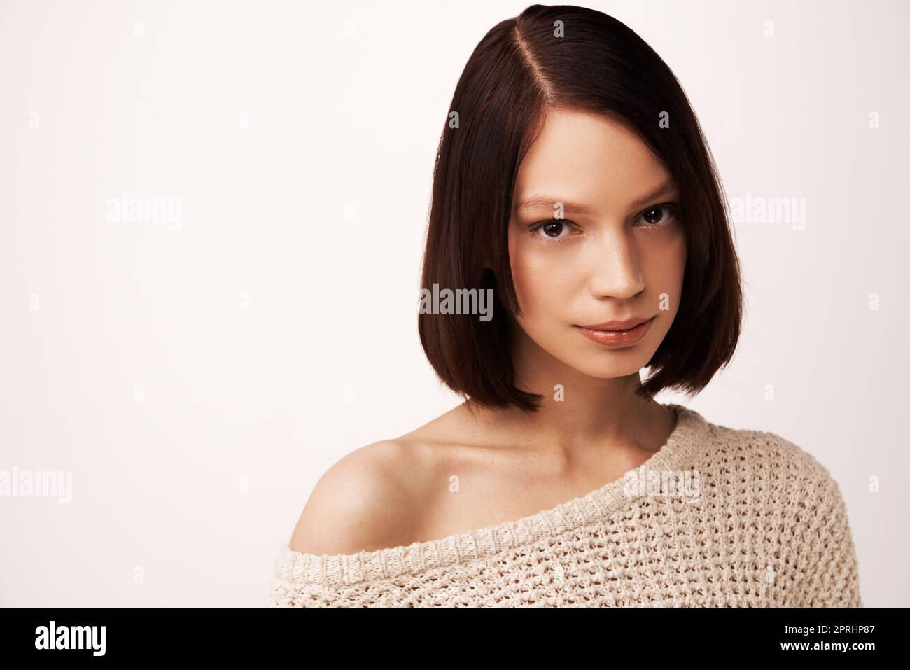 Feeling calm and placid. Dark-haired young woman against a white ...