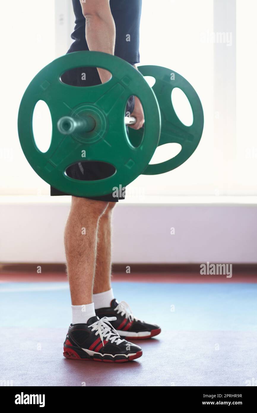 Building the perfect body. a man working out with weights in the gym ...
