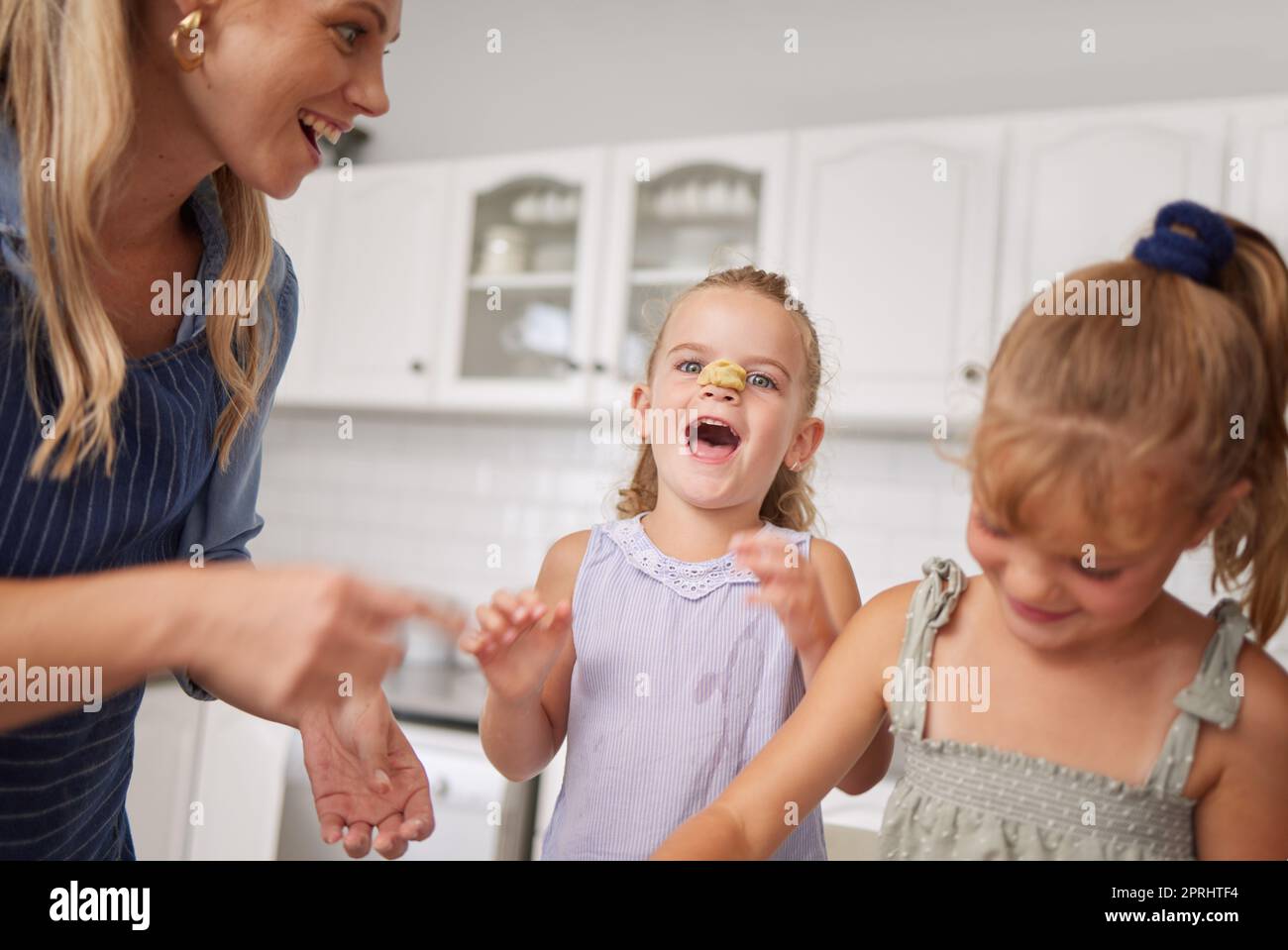 Home kitchen, children play while cooking with happy mother and funny ...